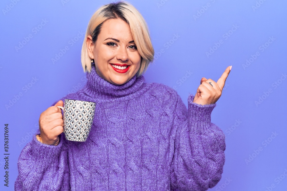 Young beautiful blonde plus size woman drinking mug of hot coffee over ... Young beautiful blonde plus size woman drinking mug of hot coffee over ...