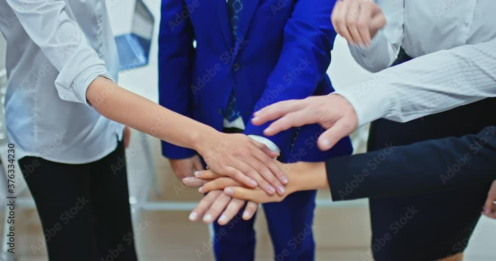 Close-up, group of businessmen stands in a circle and puts their hand ...