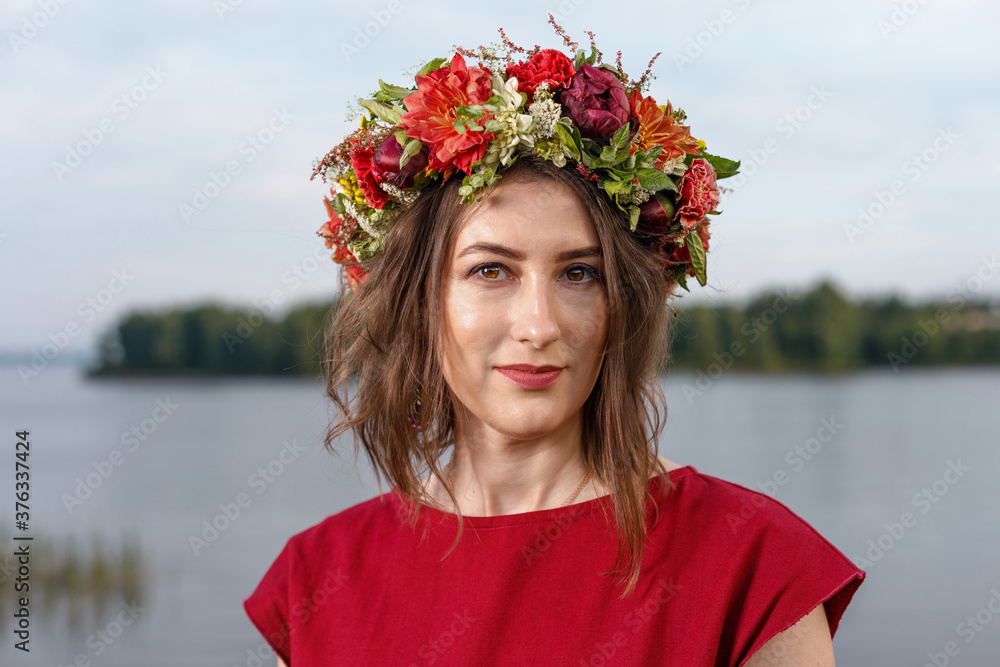 Slavic beauty with a flower wreath on her head in the lap of nature ...