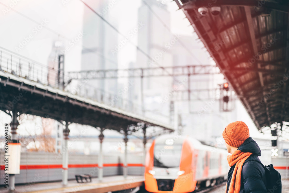 Man standing on a train platform and waiting a train in a train station ...