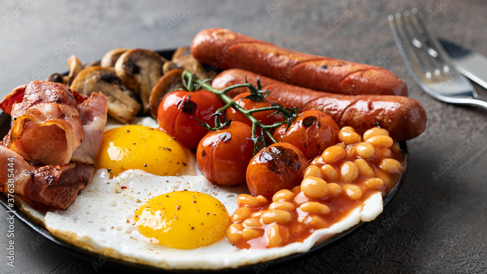 Typical English breakfast on dark concrete background. Fried eggs ...
