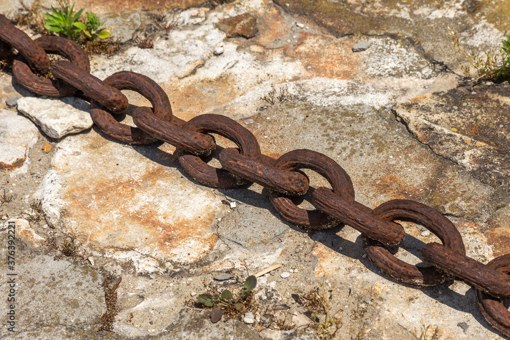The old rusty metal chain of the anchor of the ship. Giant heavy steel ...
