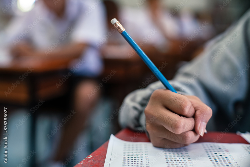 Close up Students writing and reading exam answer sheets exercises in ...