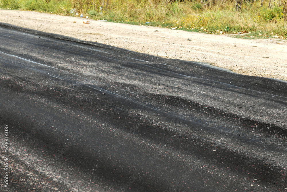 Damaged road, damaged chopped asphalt with potholes and spot. Very bad ...
