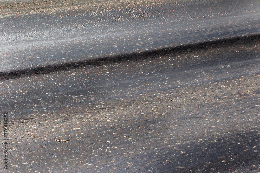 Damaged road, damaged chopped asphalt with potholes and spot. Very bad ...