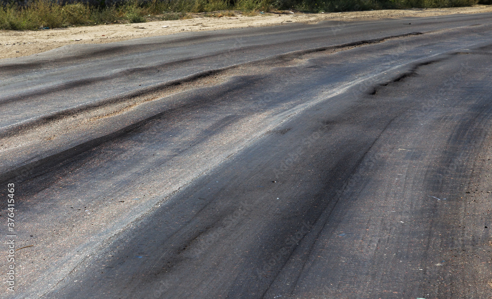 Foto de Damaged road, damaged chopped asphalt with potholes and spot ...