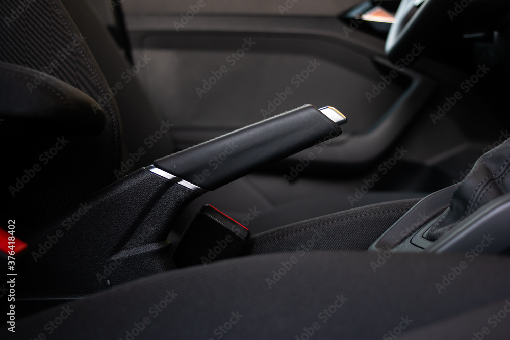 Generic black leather wrapped car hand break lever pulled up front view ...