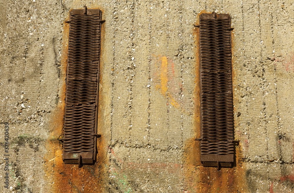 Rusty old ventilation grille on a concrete wall with streaks of rust ...