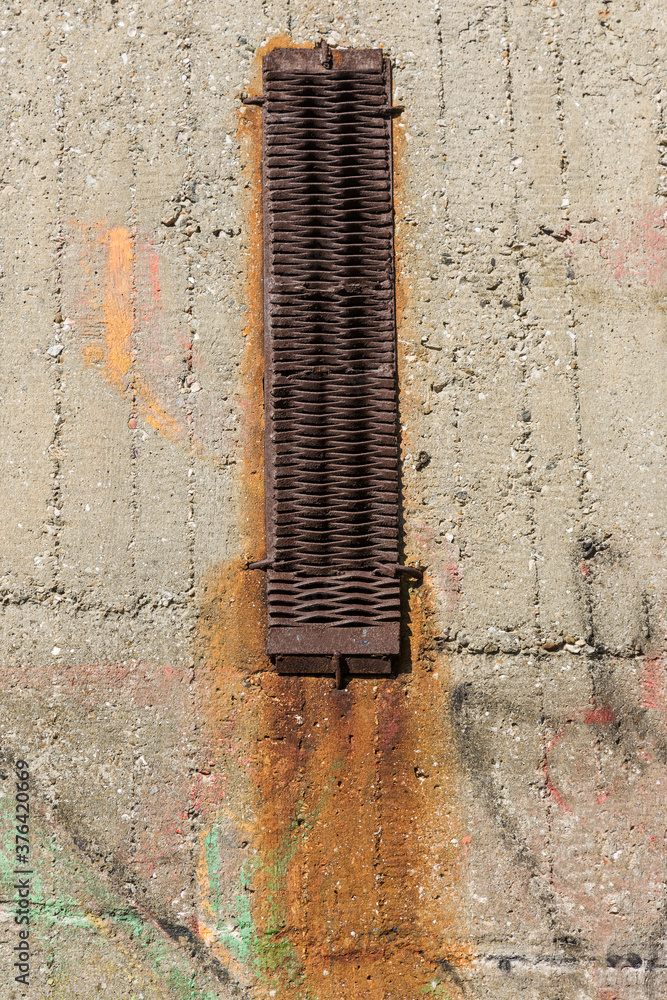 Rusty old ventilation grille on a concrete wall with streaks of rust ...