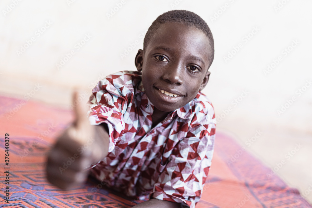 African schoolboy giving the thumbs up in front of White Background ...