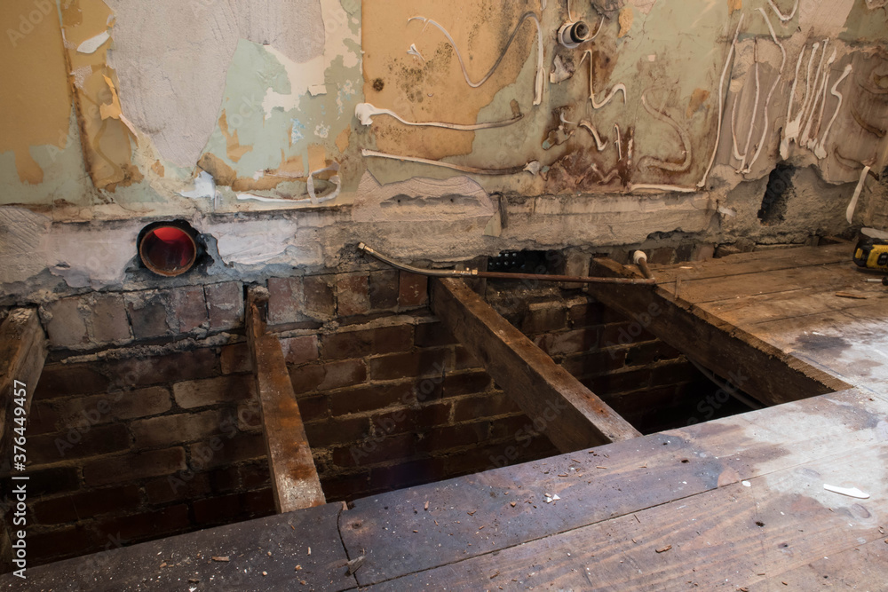 Hole in floorboards during home renovation showing into house ...