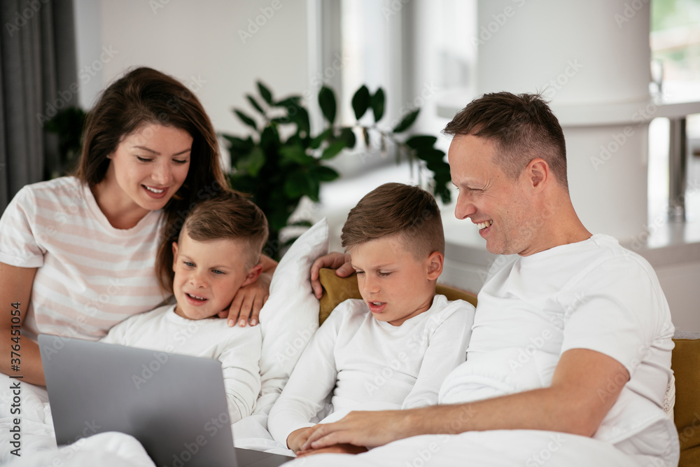 Beautiful parents with kids enjoying at home. Young family watching ...