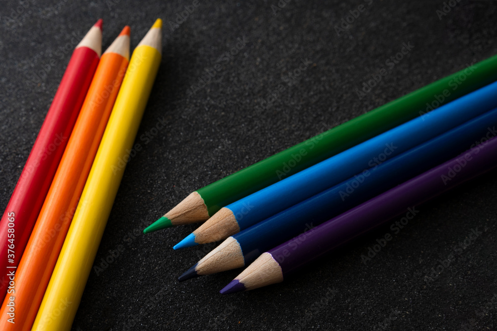 Bright colored pencils on a dark black background. Seven colors of the ...