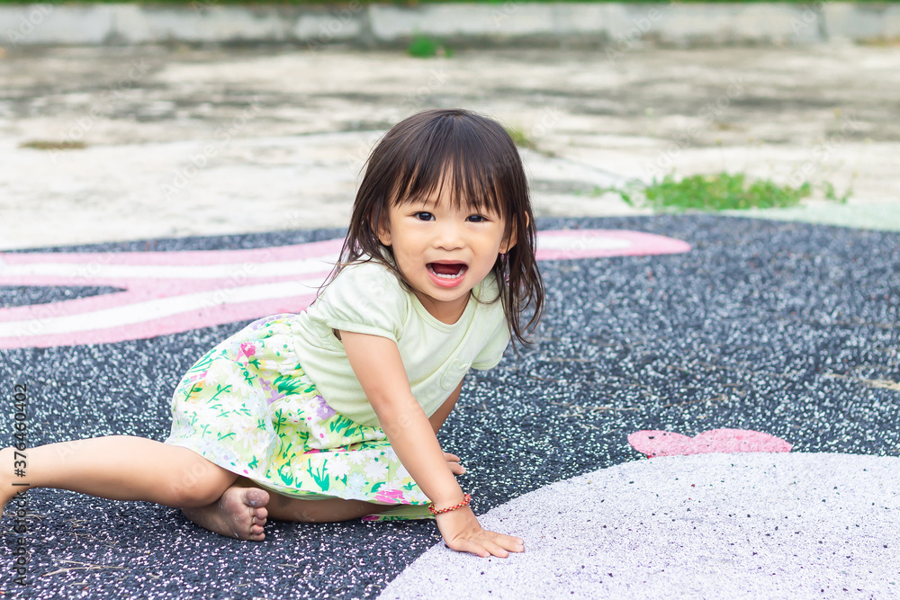 Asian baby child girl falling and laying on the floor grass field ...