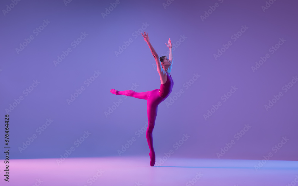 Beautiful. Young and graceful ballet dancer isolated on purple studio ...