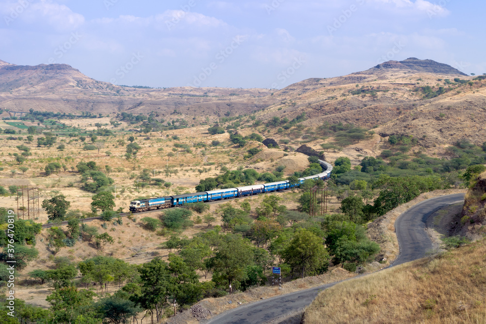 Train on a curved track with background of hills and sky and a ...