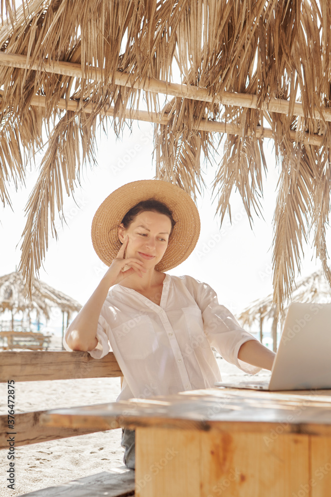 Young woman using laptop computer on a beach. Freelance work concept ...