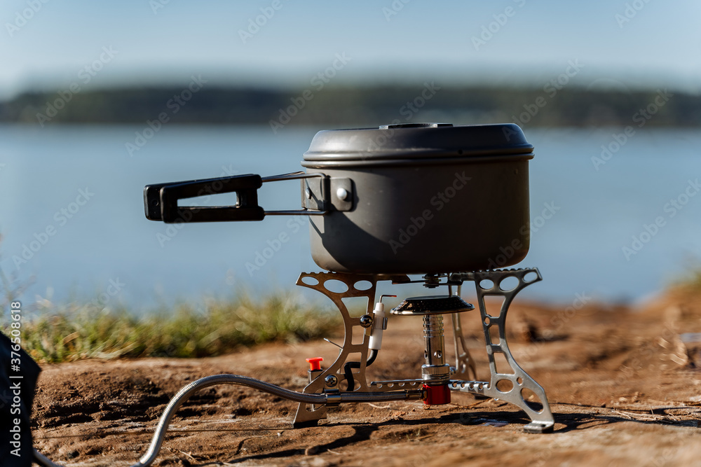 cooking on a gas burner in nature, gas camping stove for cooking food ...