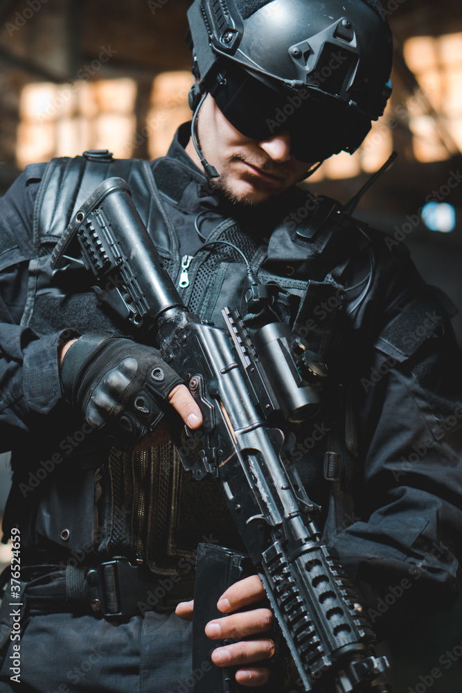 Special forces soldier in black uniform reloading the rifle. Stock ...