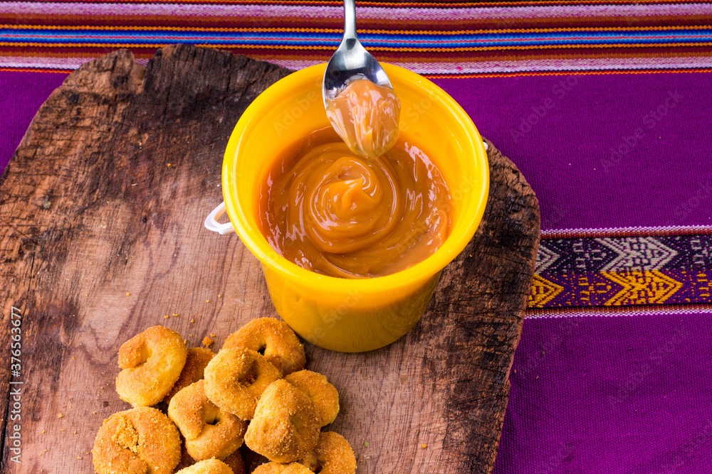 Dulce manjar blanco con cuchara de metal y rosquillas artesanales y ...