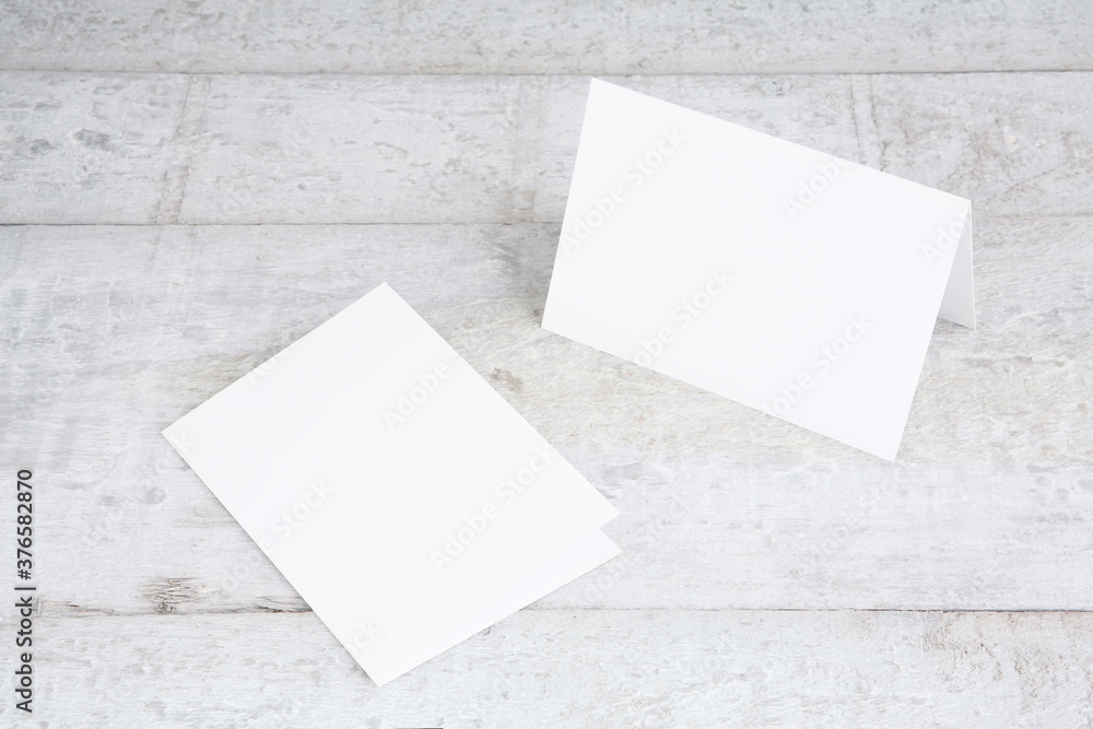Two white greeting cards mockup on a white wooden desk. Blank, closed ...