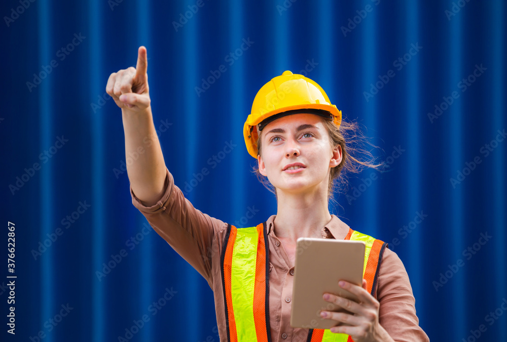 Happiness Female engineer in hard hat and safety vest holding tablet ...