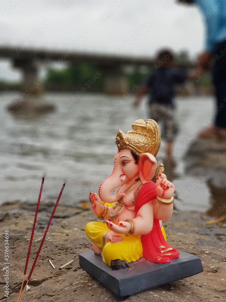 Small ganpati idol on the rock near the river side. Ganpati idol before ...