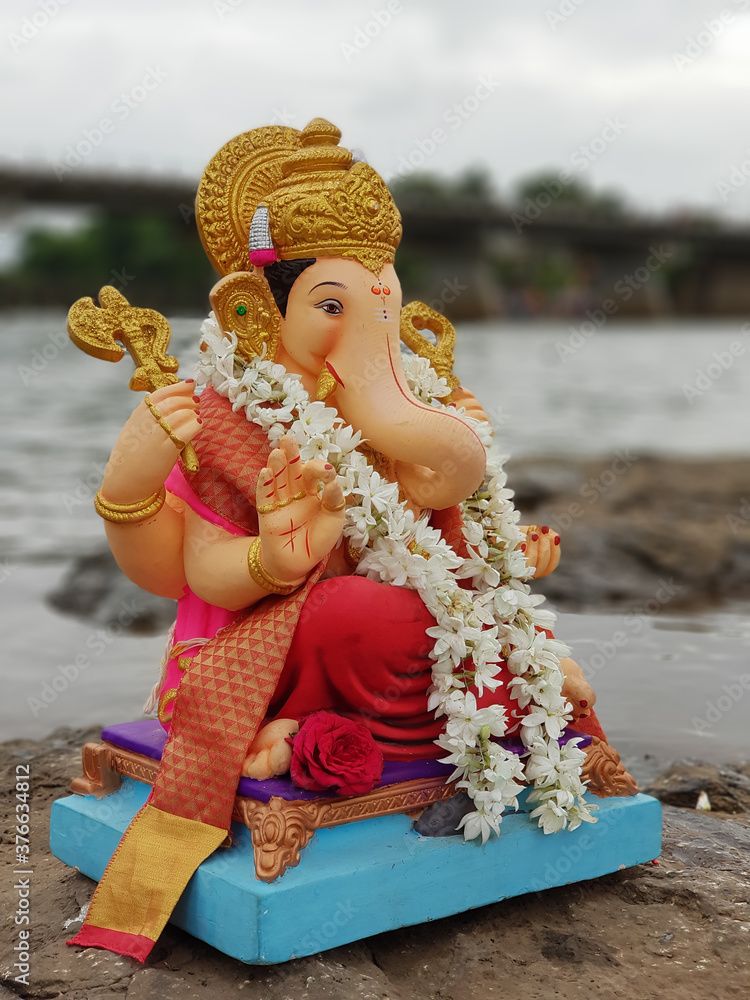 Beautiful decorative ganpati idol on the rock near the river side ...
