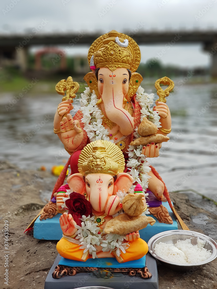 Foto de Front view of two ganpati idols on the rock near the river side ...