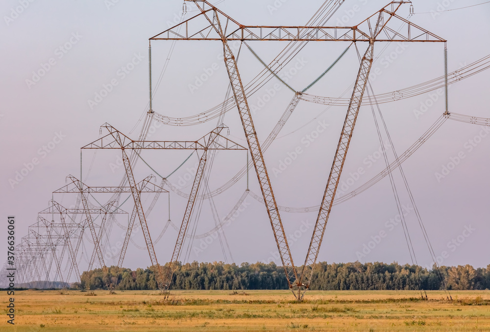 Perspective low angle view of high voltage power lines and poles in the ...