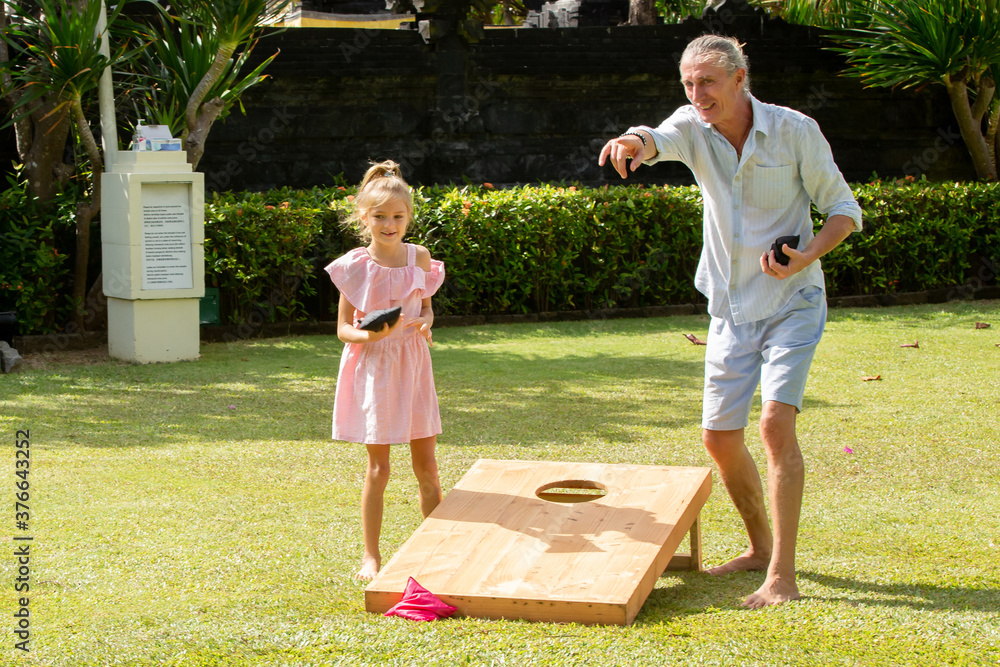 Happy family playing cornhole game outdoor on sunny summer day. Parents ...