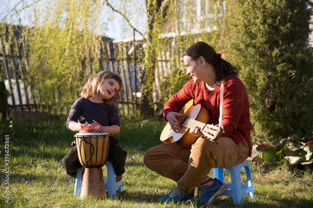 Happy family mom and child daughter having fun with musical instruments ...