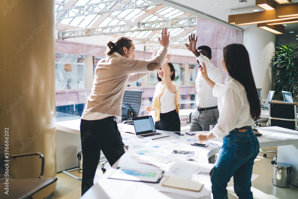 Emotional multiracial team of employees satisfied with productive ...
