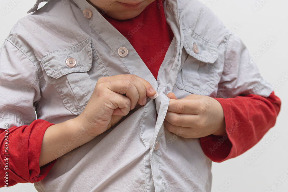 Childhood independence concept ,little boy buttoning on shirt ...