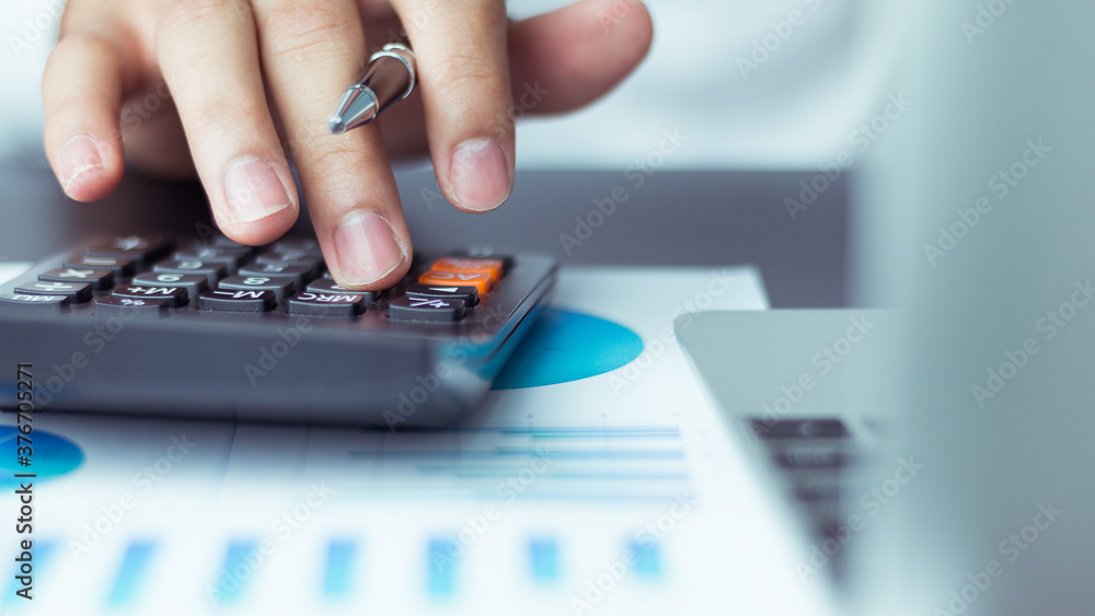 business people who use a calculator with financial concepts ...