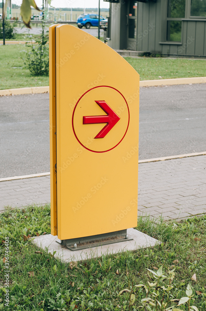 Red color paint arrow sign in white circle sharpe on yellow background ...