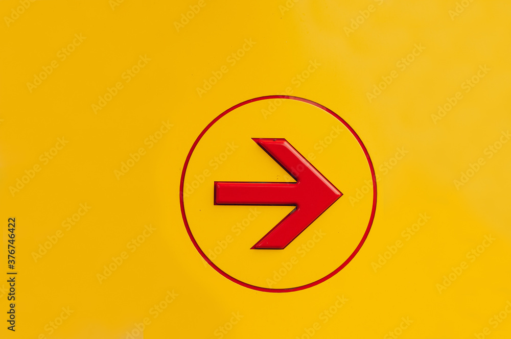 Red color paint arrow sign in white circle sharpe on yellow background ...