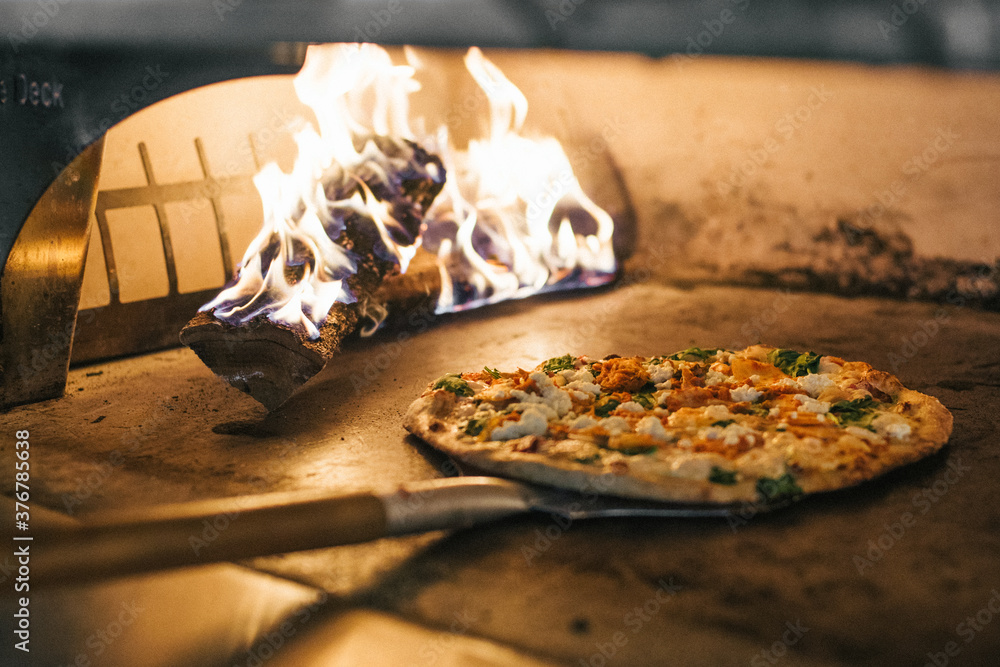 Pizza putting into woodfire stove Stock Photo | Adobe Stock