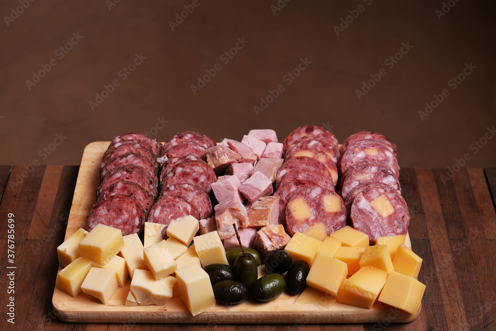picada completa sobre tabla compuesta por salame, queso, salamín, lomo ...