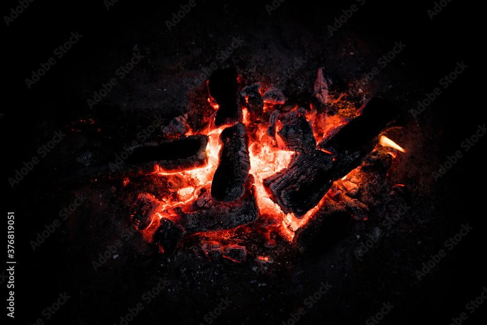 Red hot coals glowing on a dying campfire pit. Orange glow from embers ...