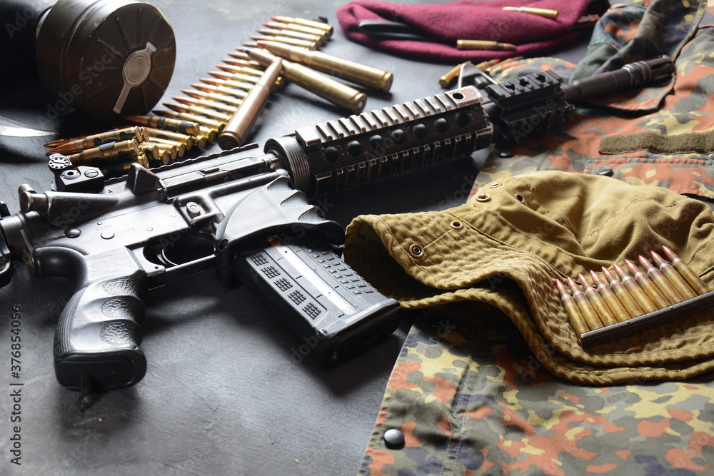 Assault rifle (M4A1) with ammunition on camouflage uniform,and military ...