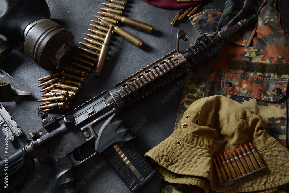Assault rifle (M4A1) with ammunition on camouflage uniform,and military ...