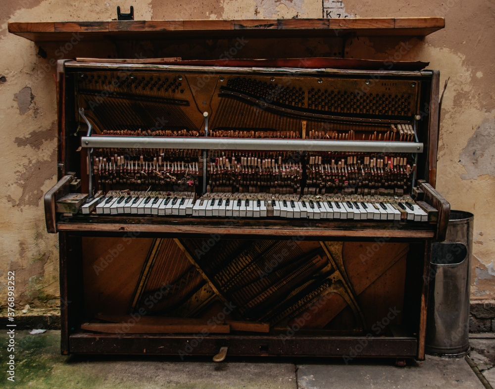 An old and forgotten piano in the city courtyard. A close-up view of a ...