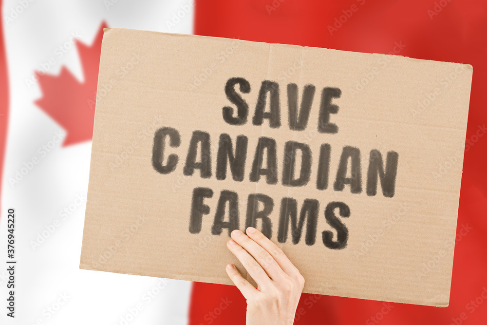 The phrase " Save Canadian farms " on a banner in men's hand with ...