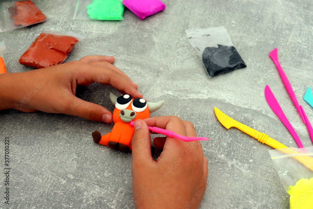 The girl is holding a figurine in the form of a bull made of airy ...