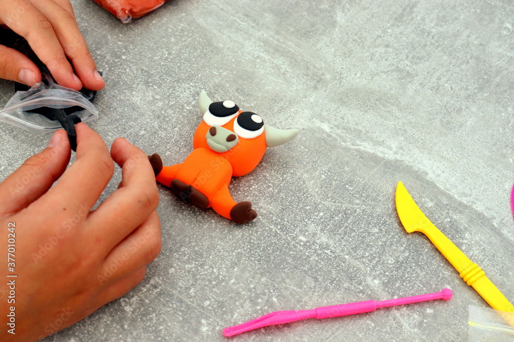 The girl is holding a figurine in the form of a bull made of airy ...