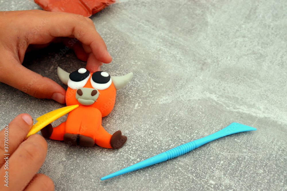 The girl is holding a figurine in the form of a bull made of airy ...