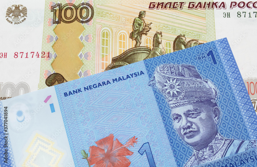 A macro image of a Russian one hundred ruble note paired up with a blue ...