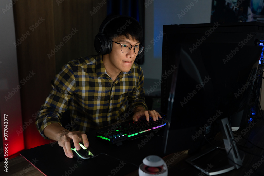 Involved asian man cyber sport gamer concentrated playing video games ...