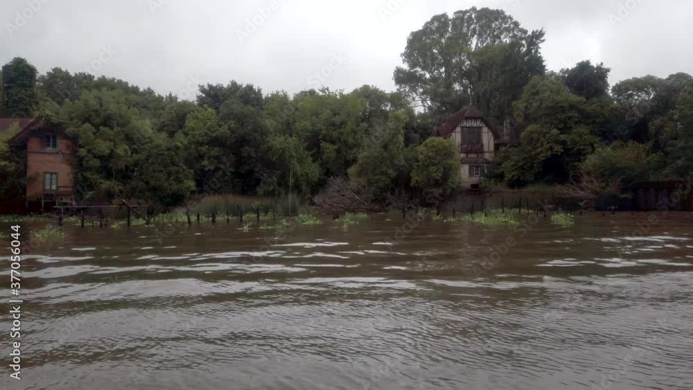 POV boat: traveling on brown dirty river water past remote countryside ...